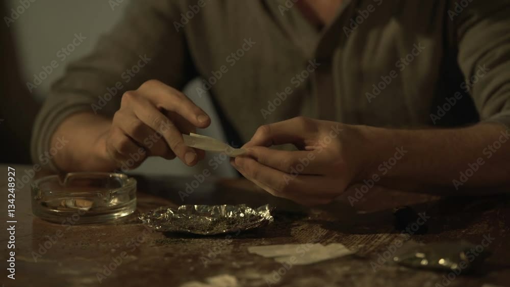 Vidéo Stock Man addicted to smoking marijuana making joint, rolling ...