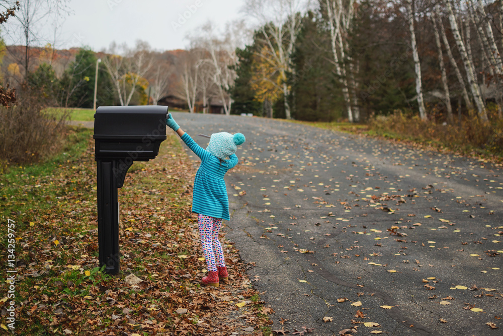 Girl collecting letter from the mail box in the street Stock Photo ...