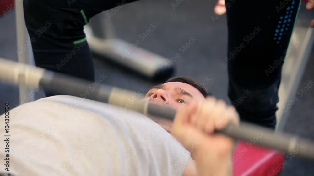 Bodybuilder. lfting. Paurlifting. The trainer insures the sports man ...