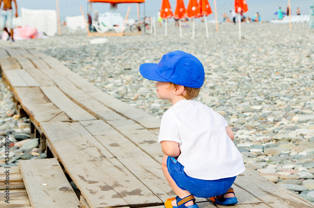 Boy in blue cap with sad expression. Resent and crouch. Frown baby boy ...