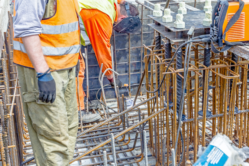 Assembling metal skeleton, welder is welding tied reinforcing ro Stock ...