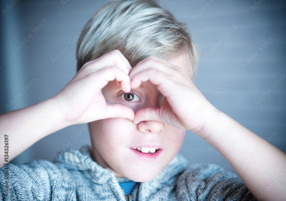 Foto Stock boy shows the heart of his hands | Adobe Stock