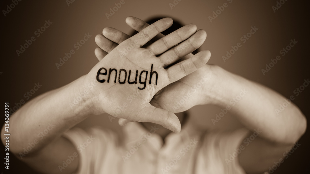 man showing the word "enough" written on the palm of a his hand Stock ...