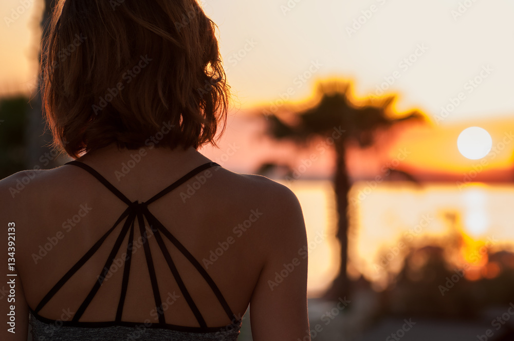 Tanned back and shoulders of teen brunette in sunset on the beach Stock ...