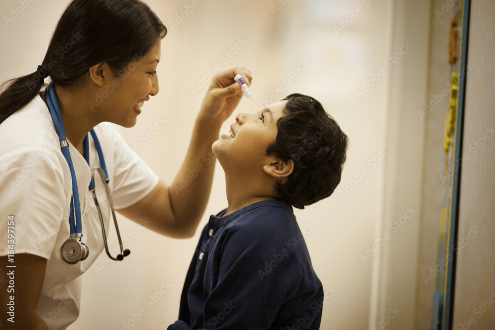 Foto Stock Nurse putting eye drops into her young patient's eyes ...