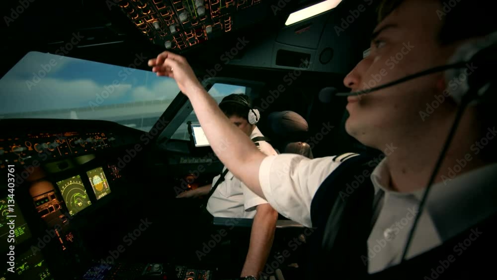 Side view of two professional pilots in the cockpit or flight deck of a ...