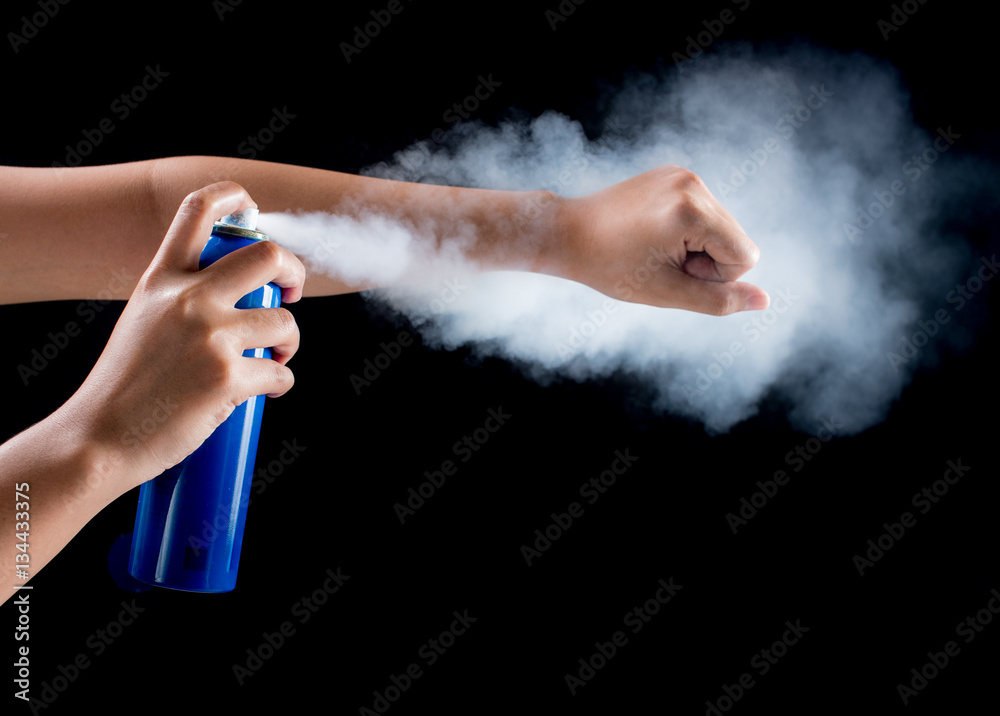 Analgesic spray can spraying on arm with black background,medica Stock ...