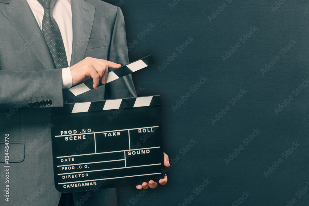 Man holding movie clapper board on black Stock Photo | Adobe Stock