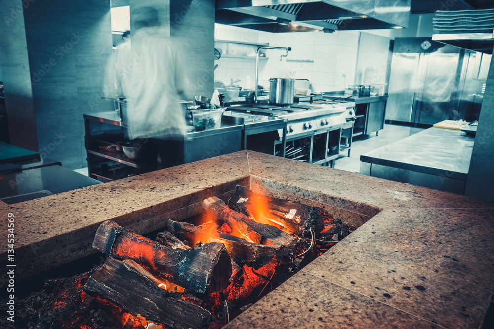 Restaurant kitchen interior: brazier with burning wood, made of natural ...