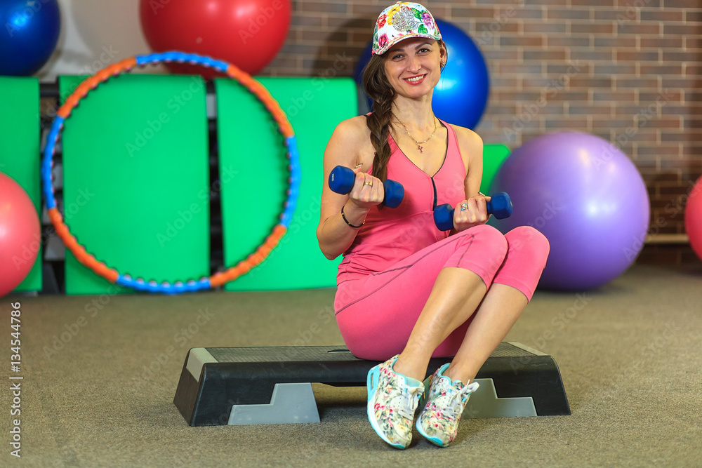 Young beautiful white girl in a pink sports suit does physical ...