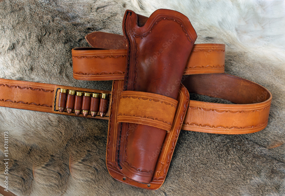 Western holster rig with ammo and deer hide background Stock Photo ...