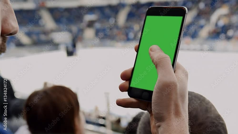 Video Stock CU Caucasian male using his phone during hockey game ...