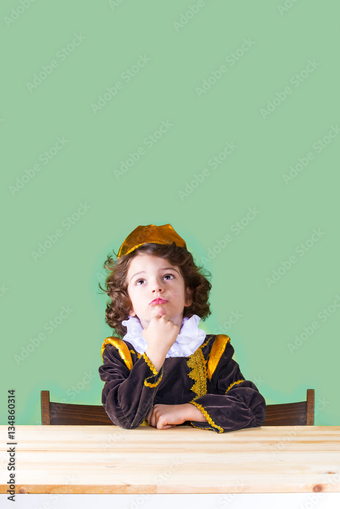 Young sad prince looks up attentively. Close-up. Green background ...