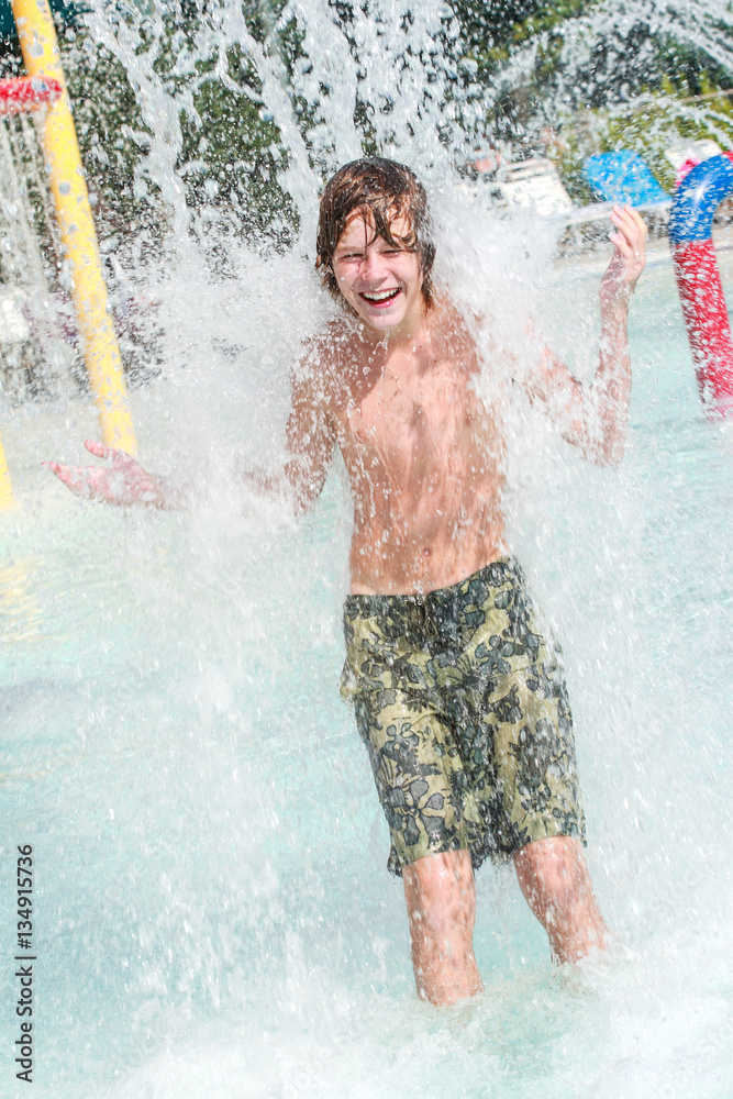 Smiling boy getting splashed with water at a waterpark Stock Photo ...