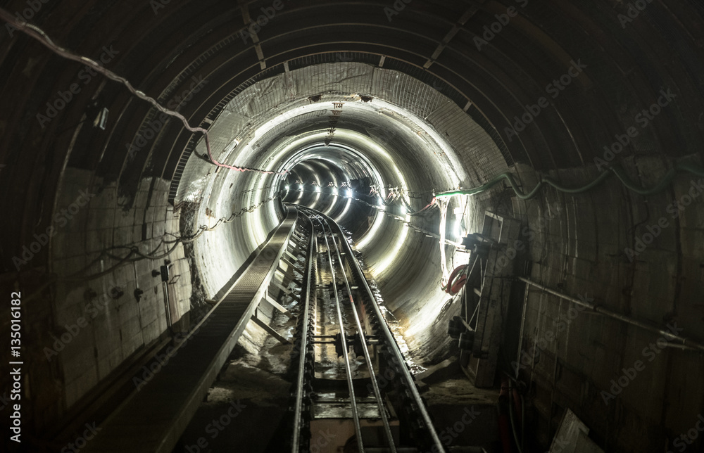 Underground mine pit tunnel gallery with working rail tracks ...