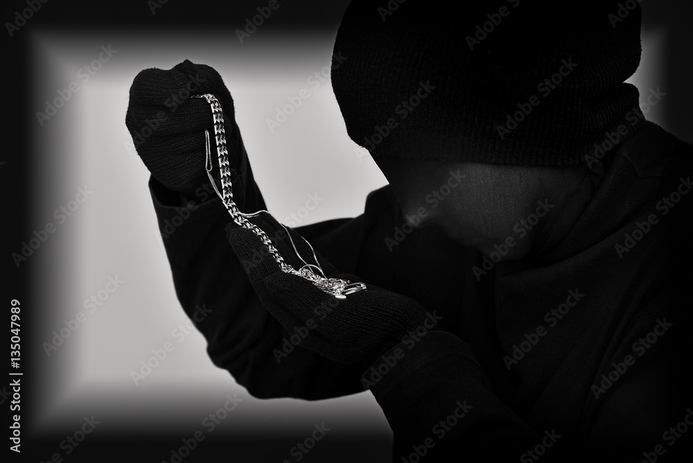 Female robber with black tights over her head holding and looking at ...