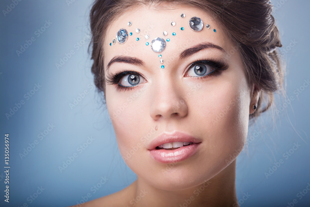 compelling woman with makeup and sequins on her face Stock Photo ...