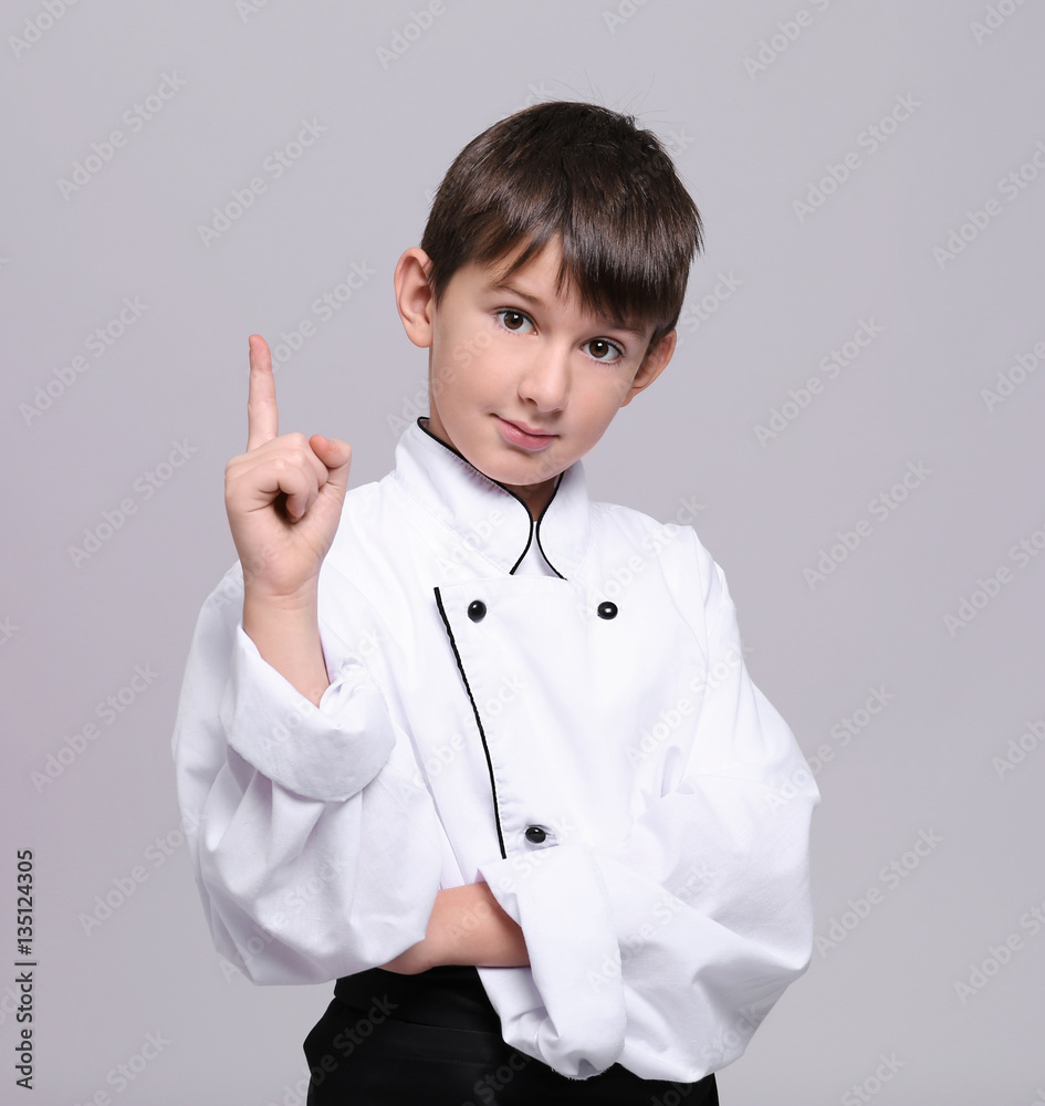 Cute boy in chef uniform on light background Stock Photo | Adobe Stock
