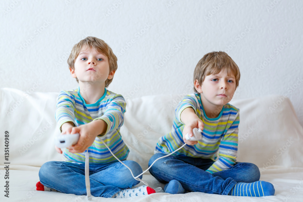 Two little kid boys playing video game at home Stock Photo | Adobe Stock