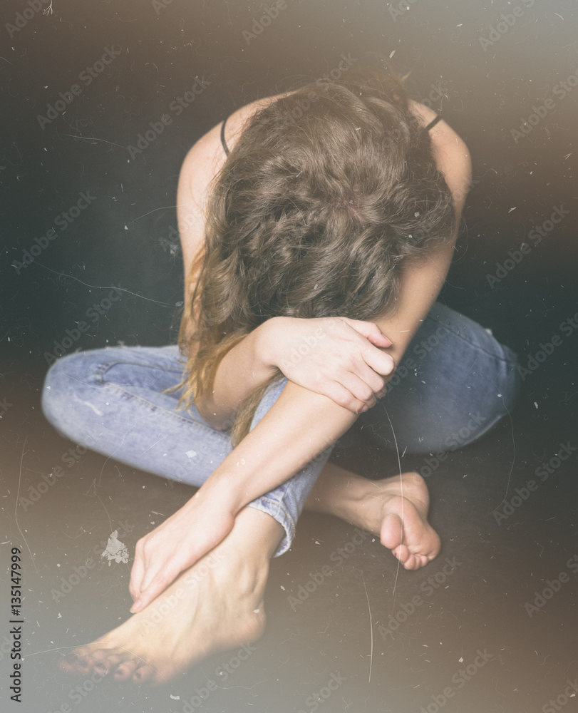 Crying shy girl curled up in the corner Stock Photo | Adobe Stock