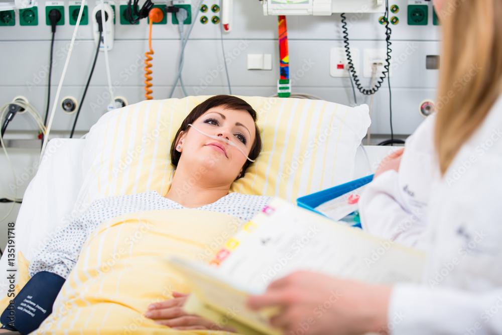 Patientin auf der Intensivstation eines Krankenhauses spricht mit ...