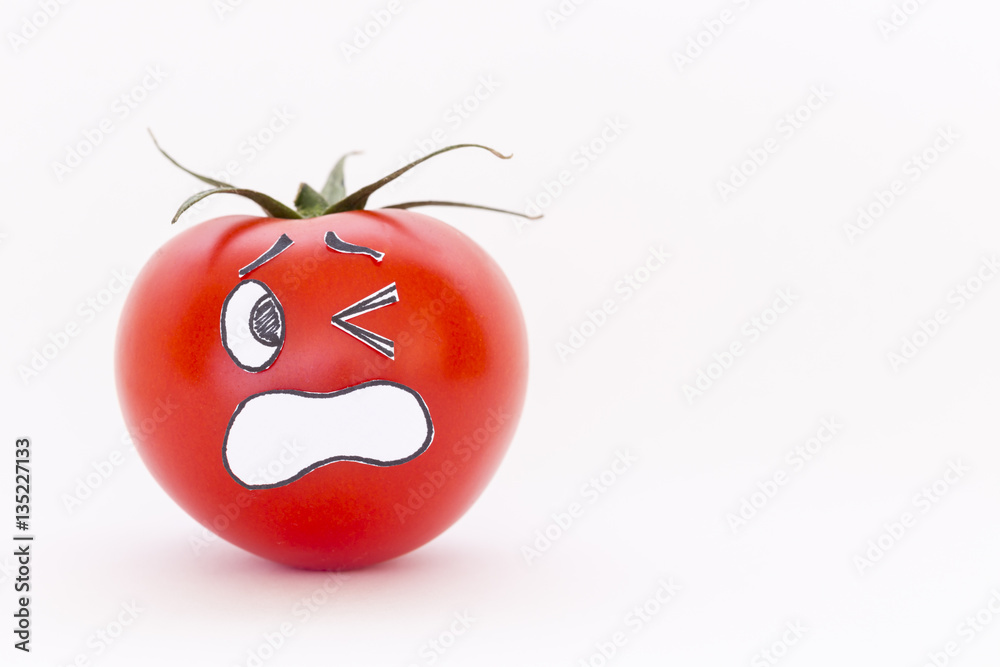 A single fresh red tomato with scared face in front of white background ...