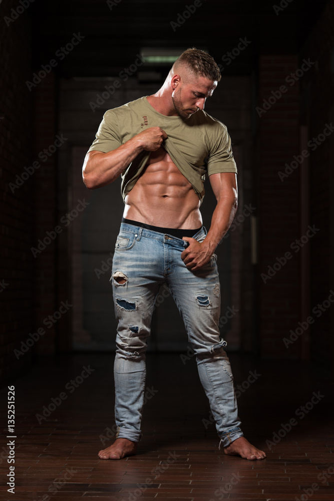 Muscular Bodybuilder In Jeans Flexing Muscles Stock Photo | Adobe Stock