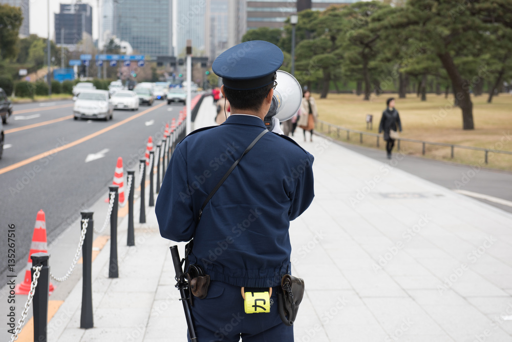 In the picture we can see a Japanese cop announcing and some people are ...
