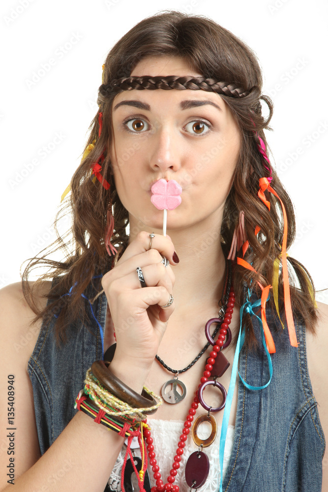 Beautiful hippie girl closes mouth candy in the shape of a flower on a ...