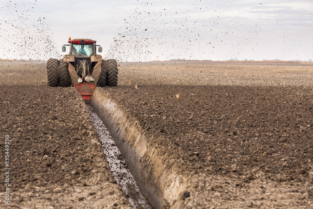 Tractor with double wheeled ditcher digging drainage canal Stock Photo ...