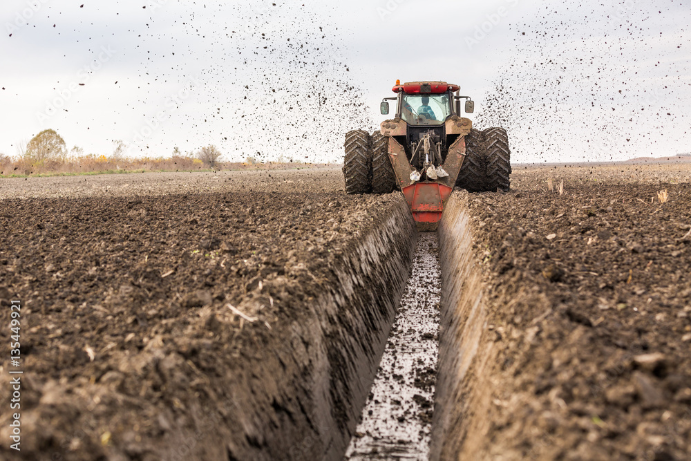 Tractor with double wheeled ditcher digging drainage canal foto de ...