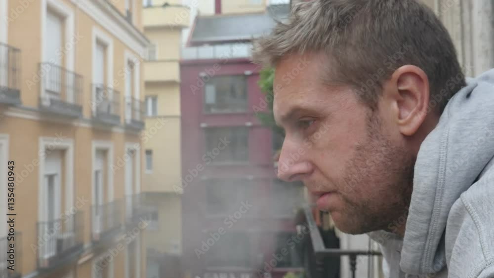 4k 24 fps video hand held cam close up young sad man in balcony looking ...