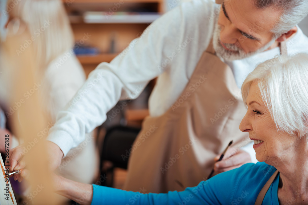 Artist helping his female colleague in painting class Stock Photo ...