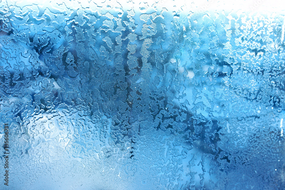 Small pieces of ice melting on the glass windows on the background of ...