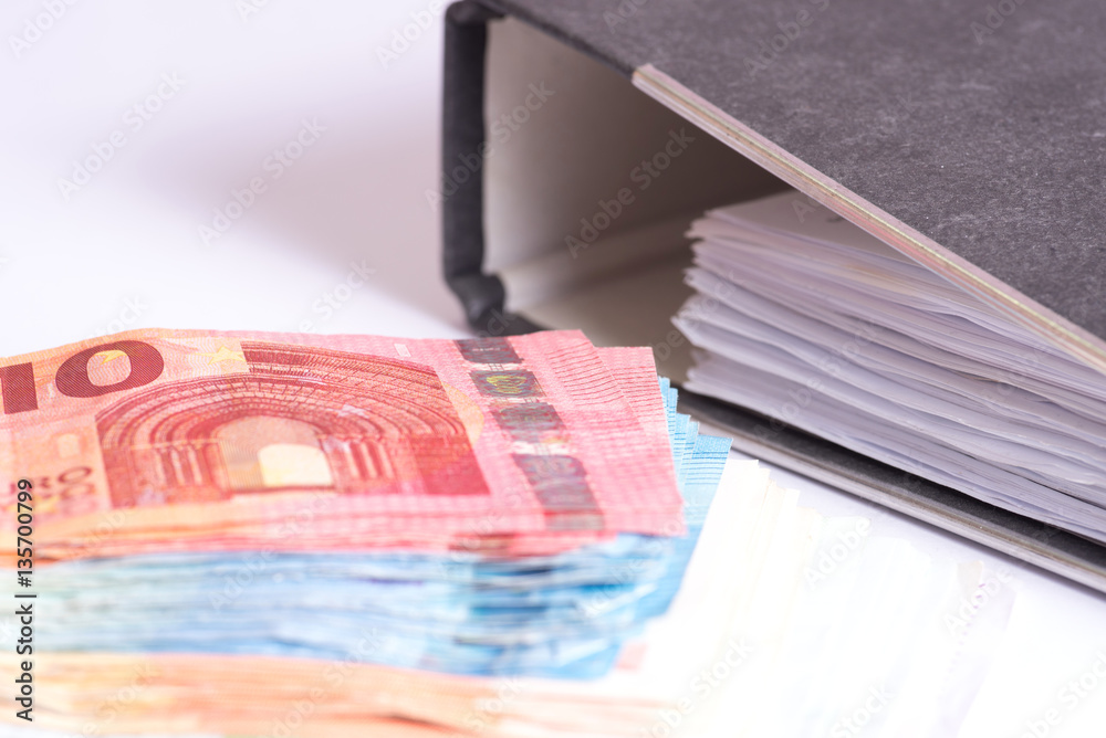 Euro Geldscheine und ein Ordner mit Unterlagen ภาพถ่ายสต็อก | Adobe Stock