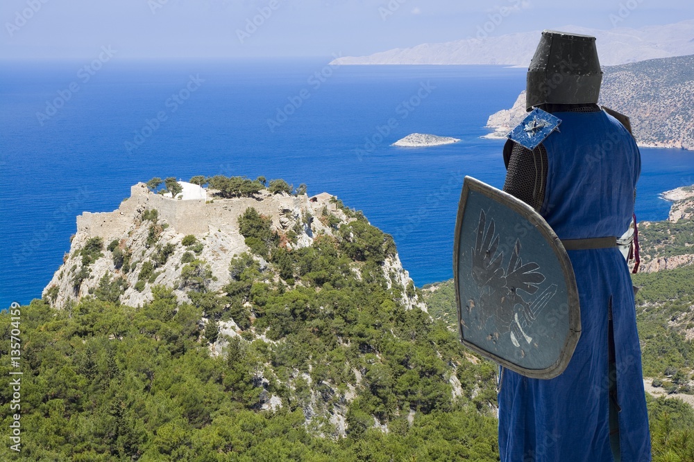 Medieval knight with ruins of a castle built by the Knights of Saint ...