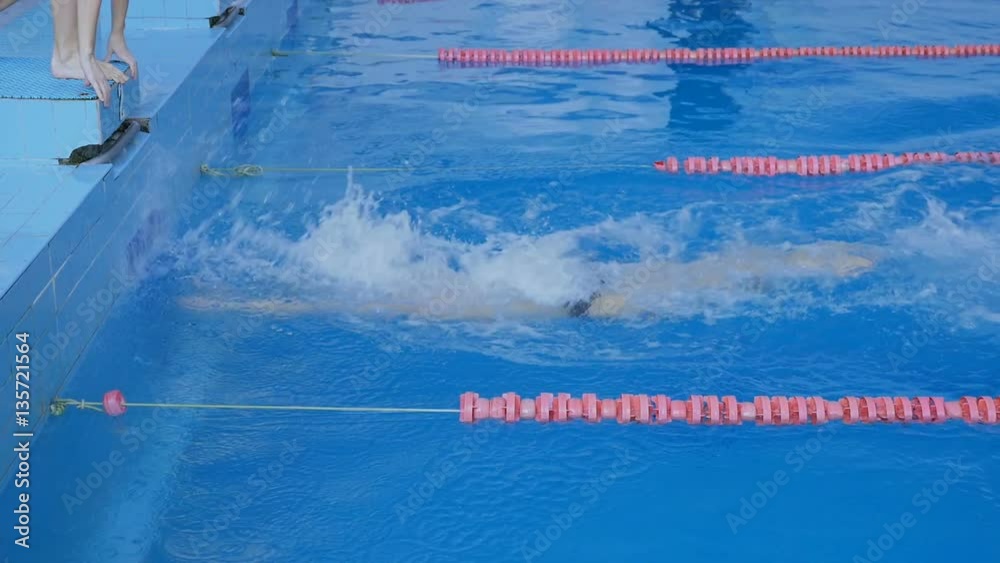 Relay Race, a man arrives to the finish line and then a woman swimmer ...