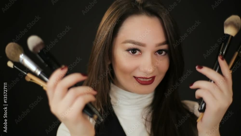 Woman hiding behind makeup brushes Stock Video | Adobe Stock