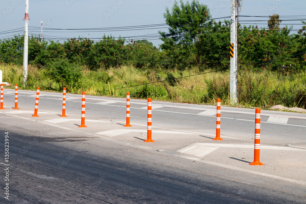 Plastic orange traffic pole on asphalt road Stock Photo | Adobe Stock