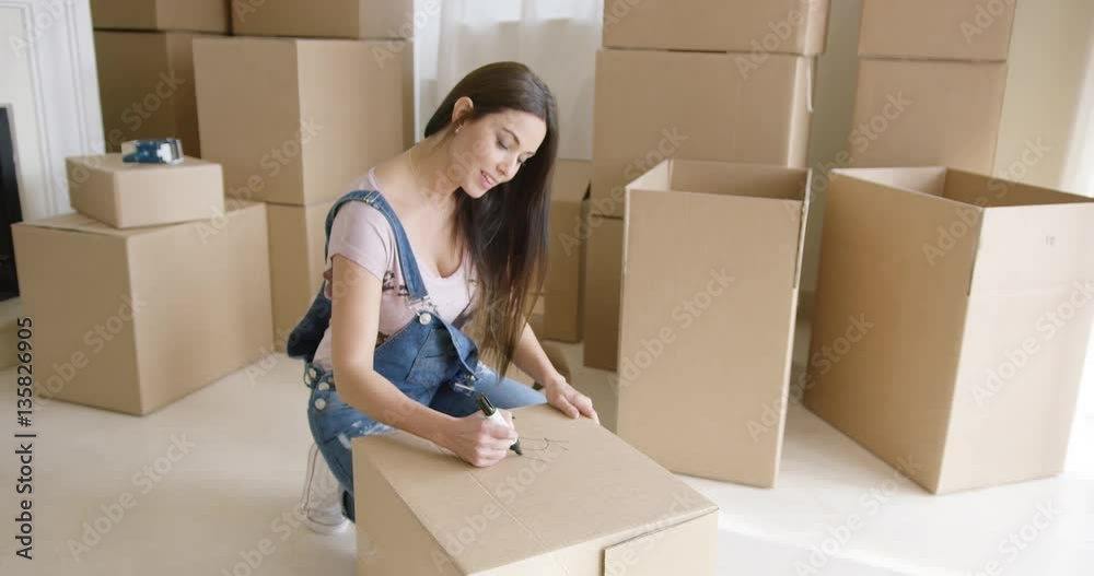 Attractive woman packing up her personal belongings as she prepares to ...
