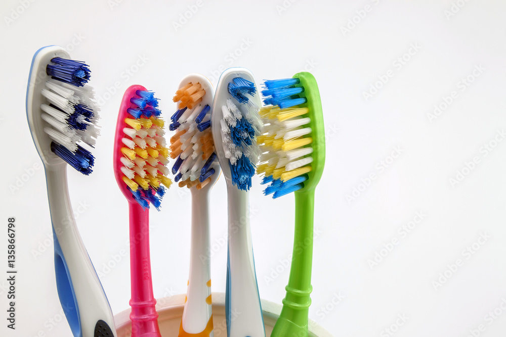 Close up shot of set of multicolored toothbrushes in glass on cl Stock ...