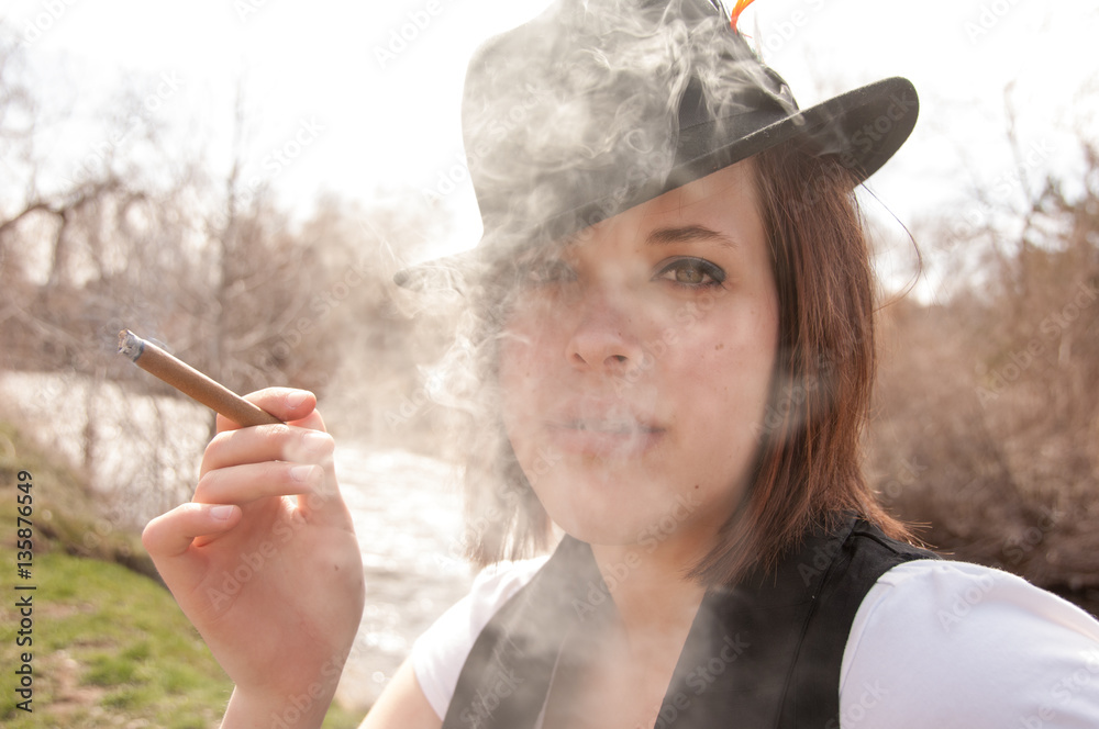 A cloud of cigar smoke blown at the camera covers the face of a cute ...