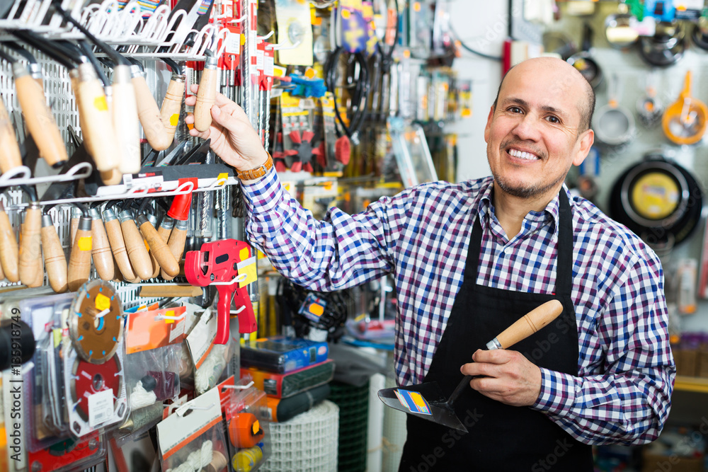 Mature seller at display with trowels Stock-Foto | Adobe Stock