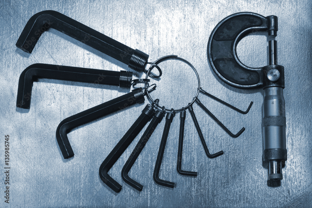 Set of hex allen keys and screw micrometer on steel background Stock ...