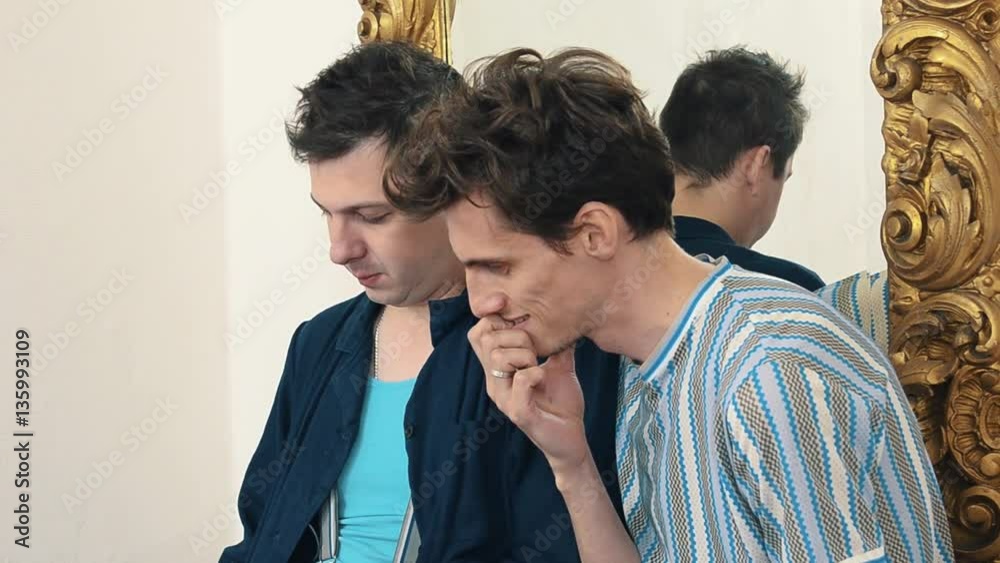 Two scared men sits in white hall at mirror arguing, close up Stock ...