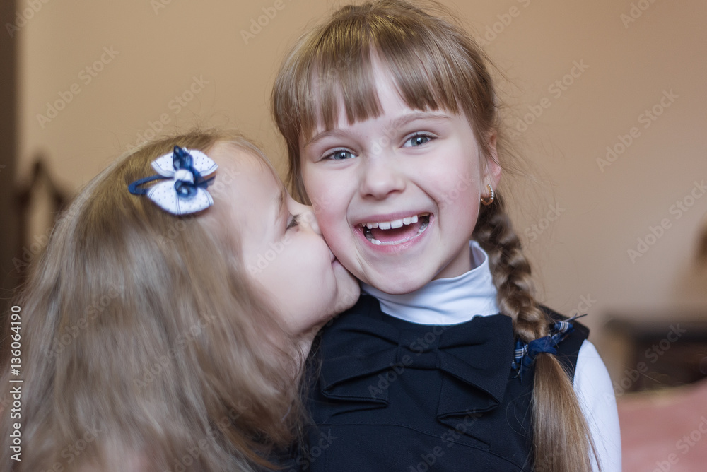 Two little girls sisters kissing on cheek Stock Photo | Adobe Stock