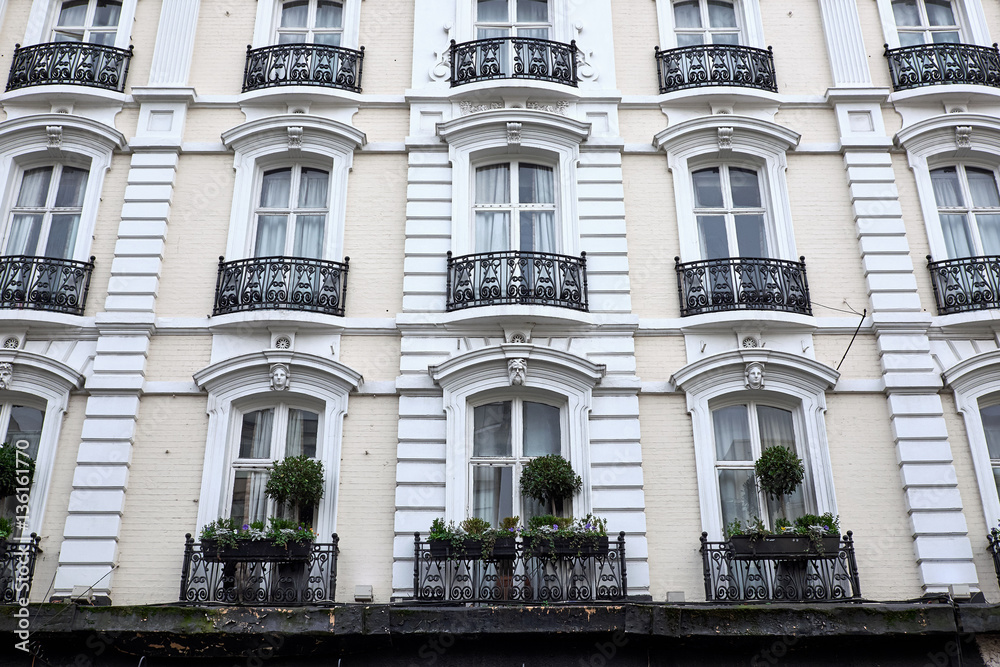 Yellow painted brick facade with white decorations around arched ...
