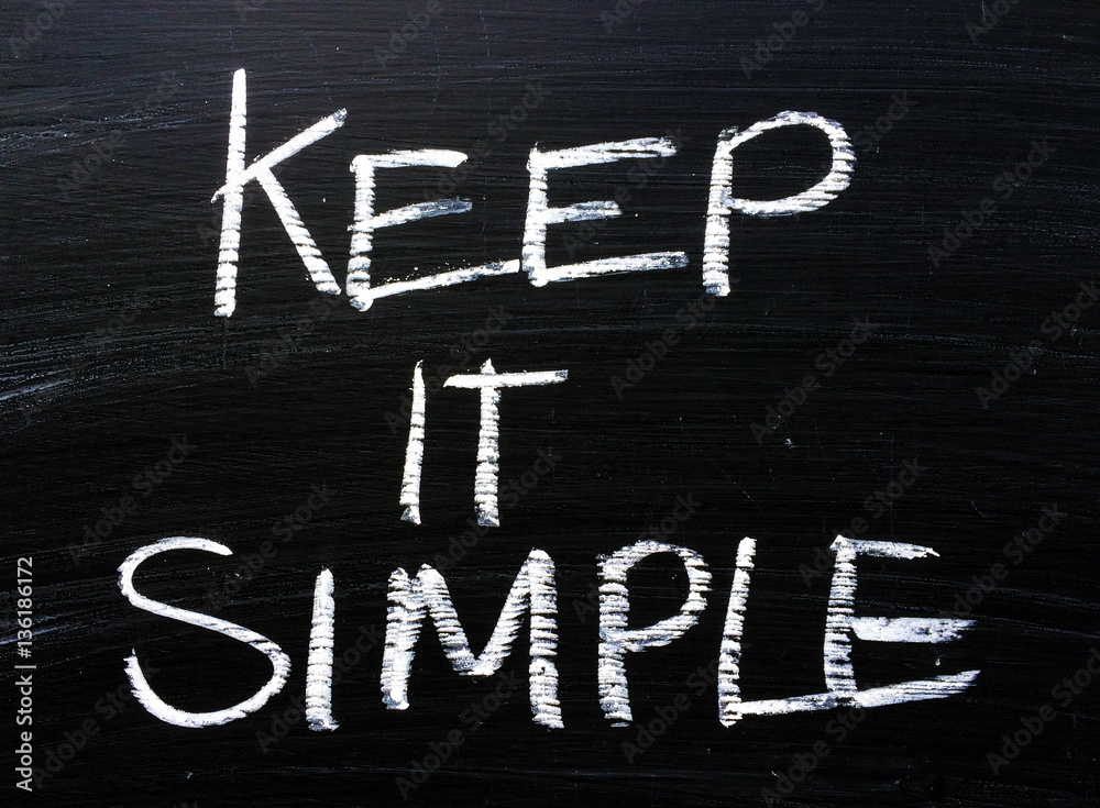 The words Keep It Simple written by hand in white chalk on a used ...