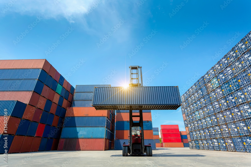 Forklift truck lifting cargo container in shipping yard or dock yard ...