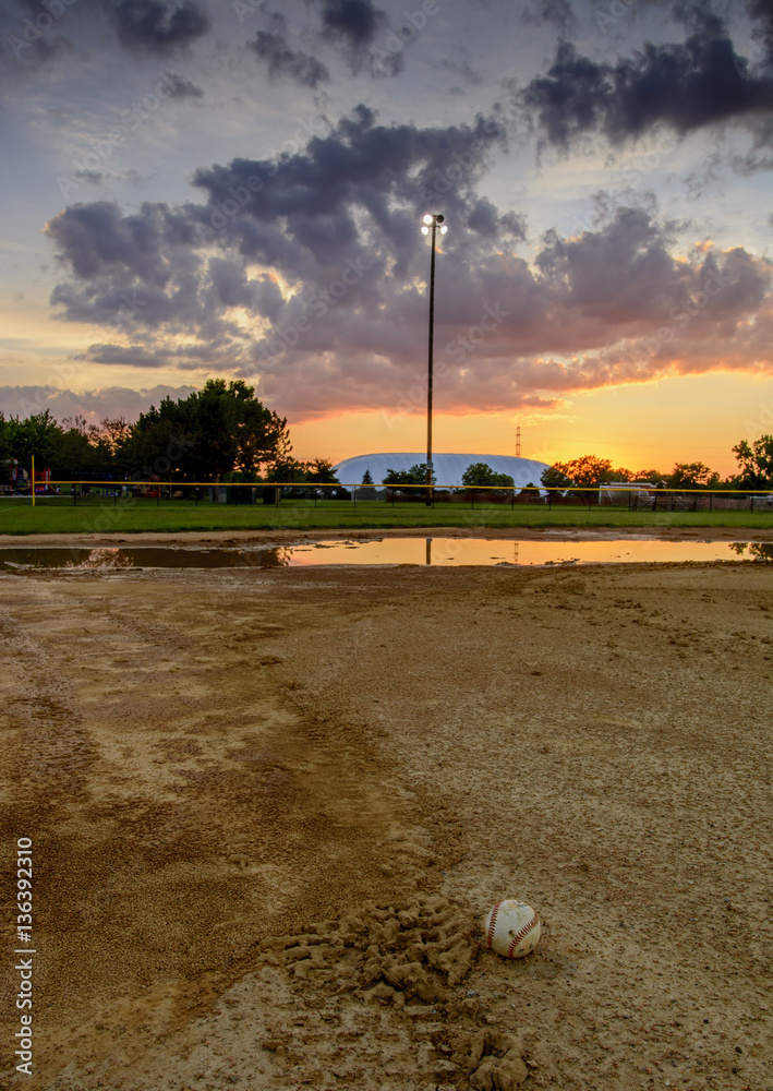 puddle at baseball field after the rain at sunset ,wet field light ,gym ...